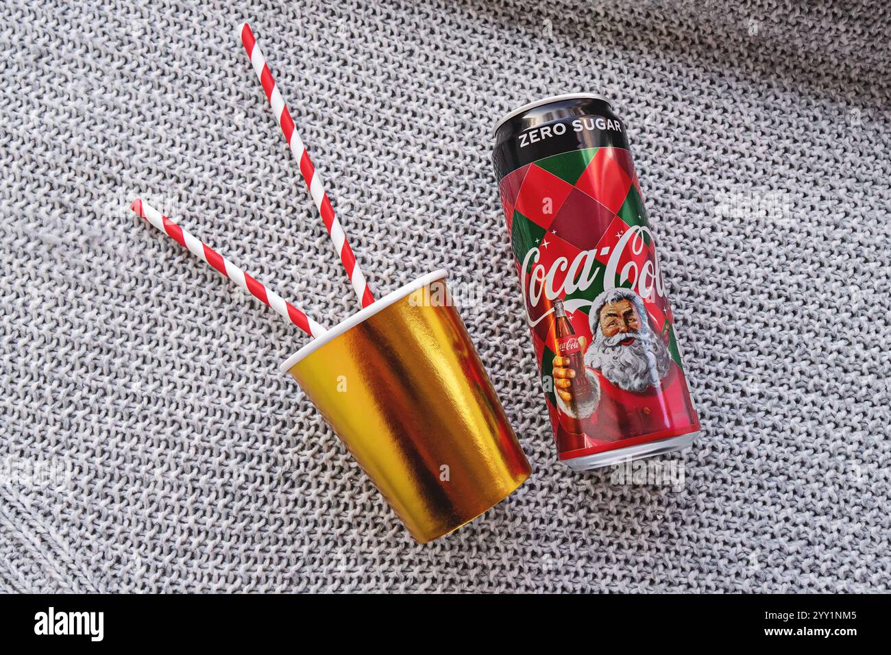 Holiday-themed drink Coca Cola can with golden paper cup with red and ...