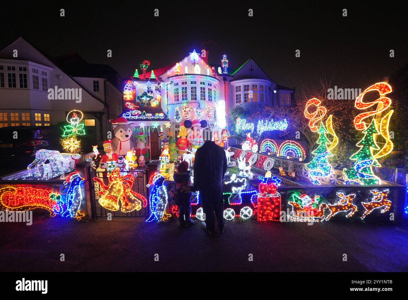 People admiring the Christmas light display at a house in Highgate ...