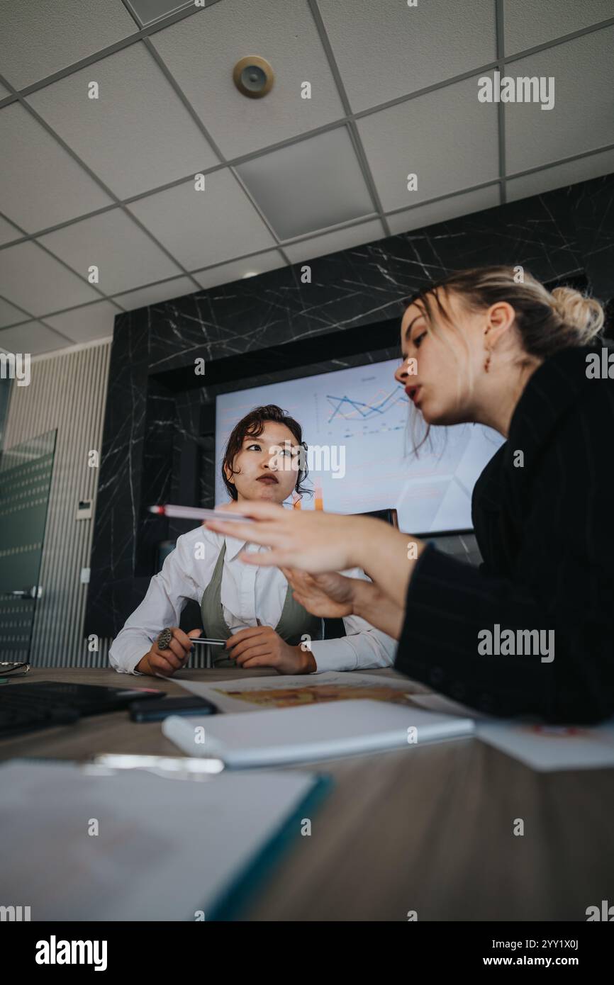 Focused team discussing project in modern office setting Stock Photo - Alamy