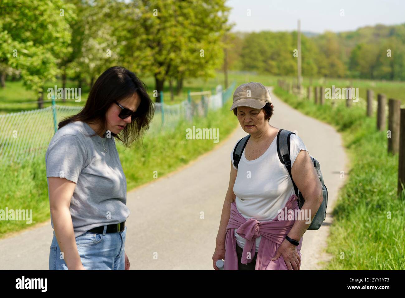 Mother and daughter walking on a country road in the countryside. Focus ...