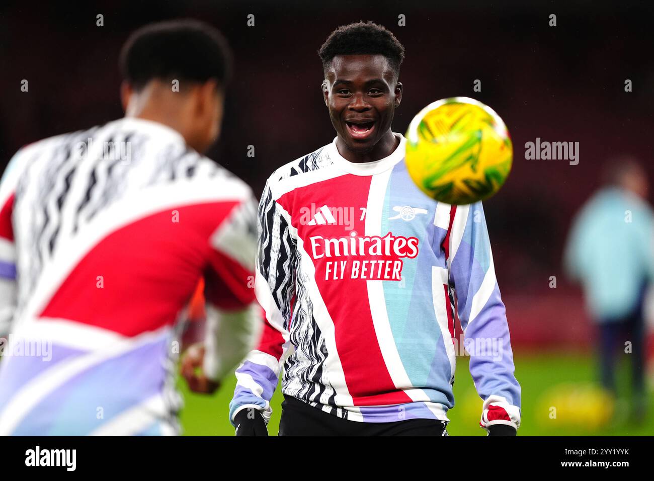 Arsenal's Bukayo Saka (facing) and team-mate warming up before the ...