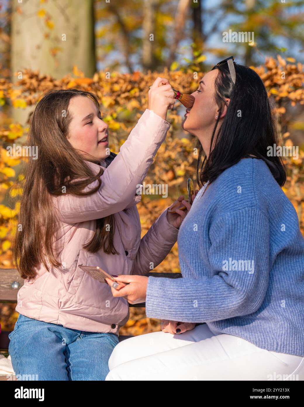 Mother and cute preschool daughter have fun together in nature in fall ...
