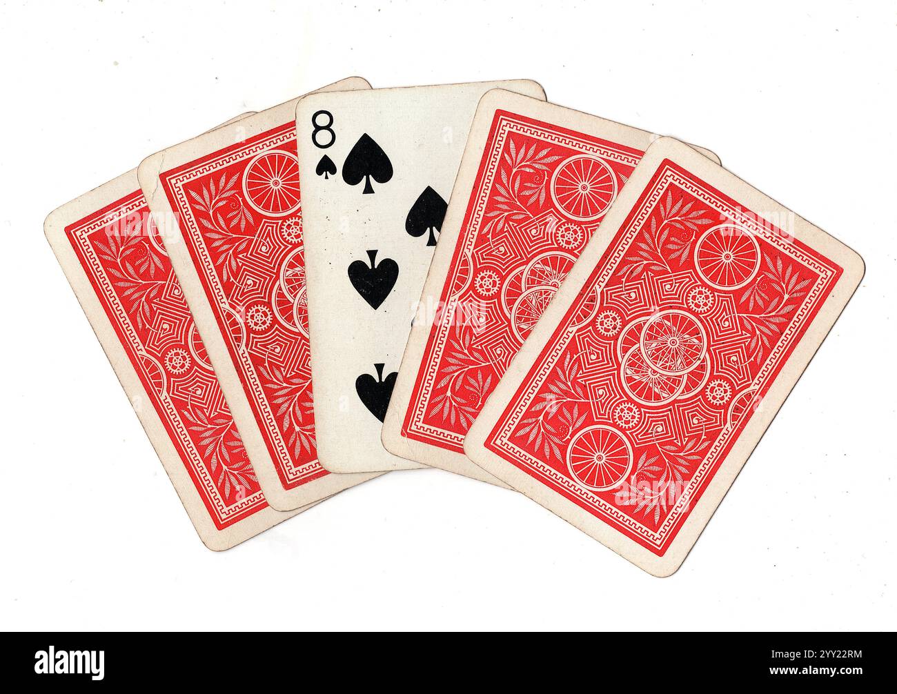 A hand of vintage playing card backs with the eight of spades revealed ...