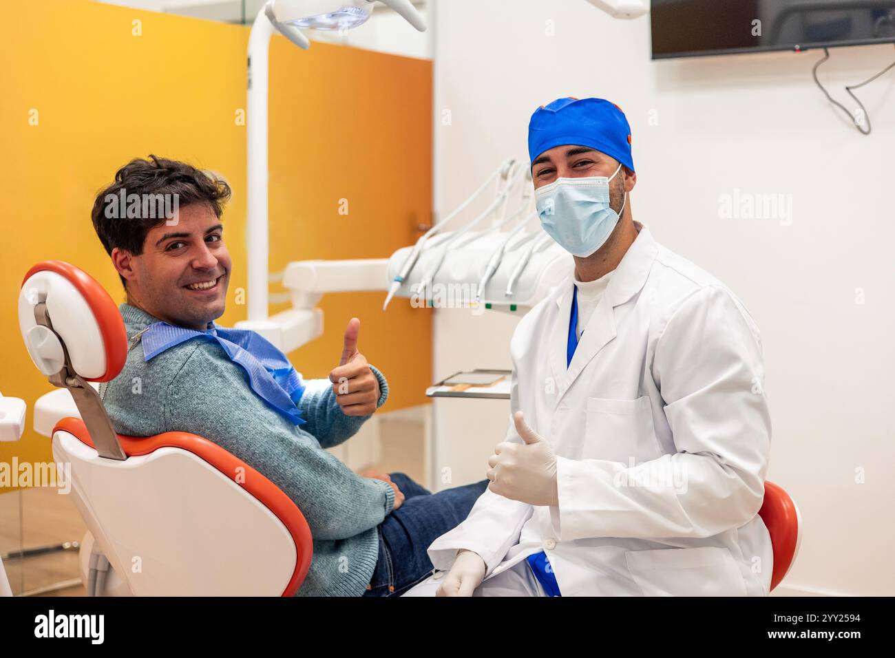 Happy dentist and patient showing thumbs up sign of satisfaction after ...