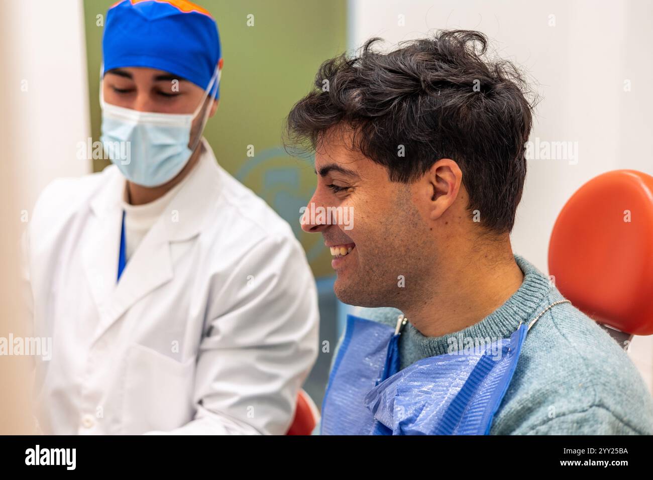 Dentist wearing a surgical mask and cap is performing a dental checkup ...