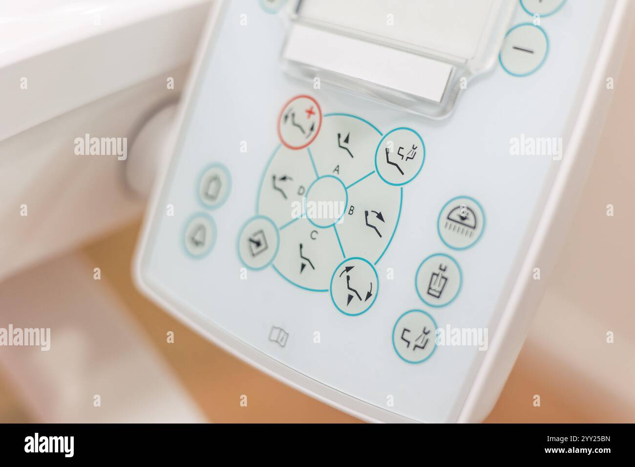 Close-up of a modern dental chair control panel, featuring various buttons and symbols for ...