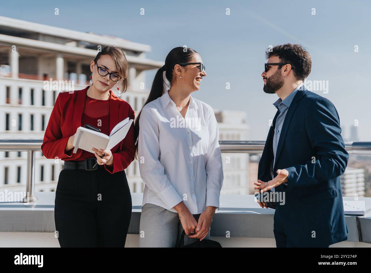 Three business people engage in a lively conversation on a sunny ...