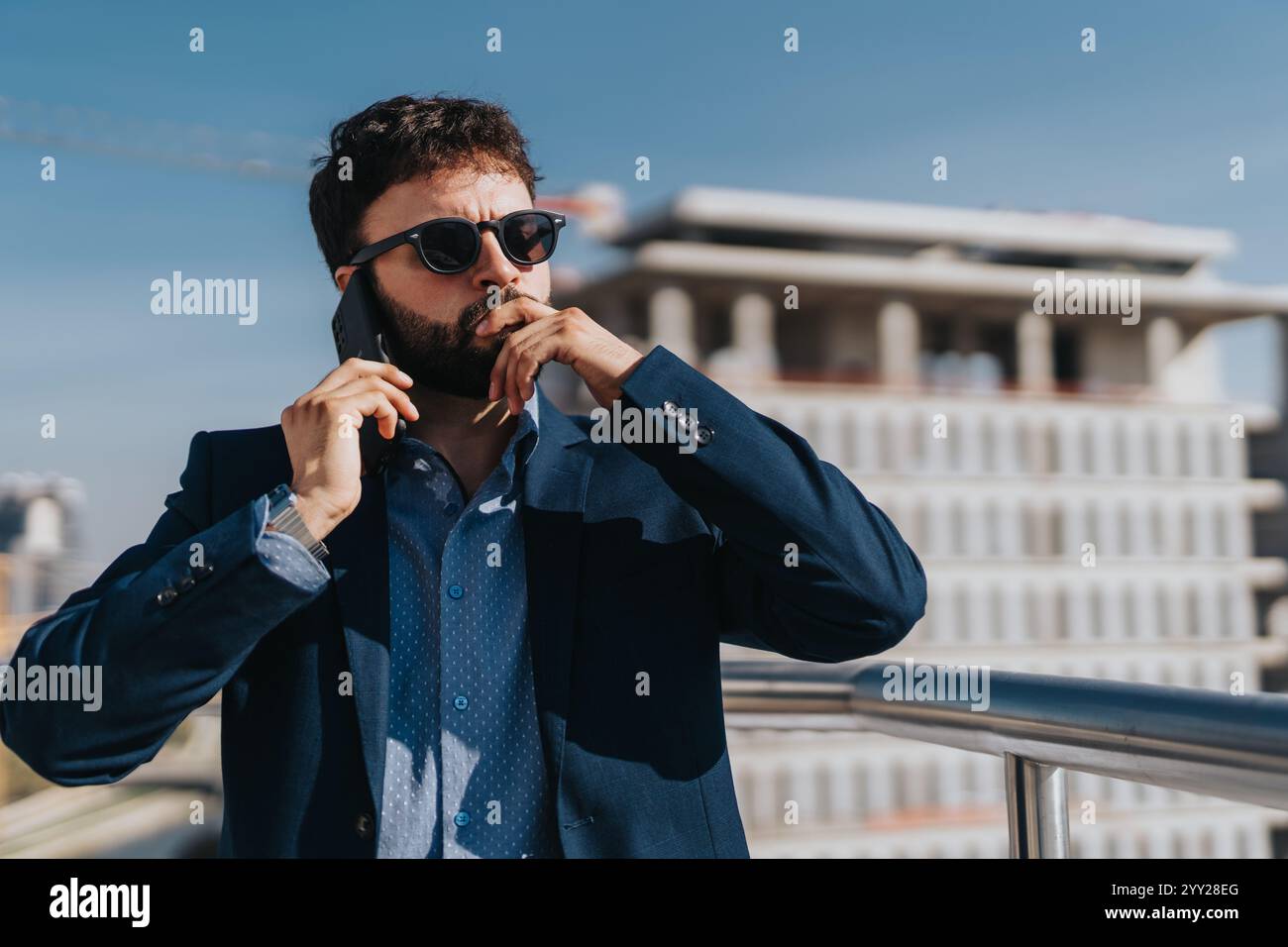 Young businessman making a phone call outside in cityscape Stock Photo ...