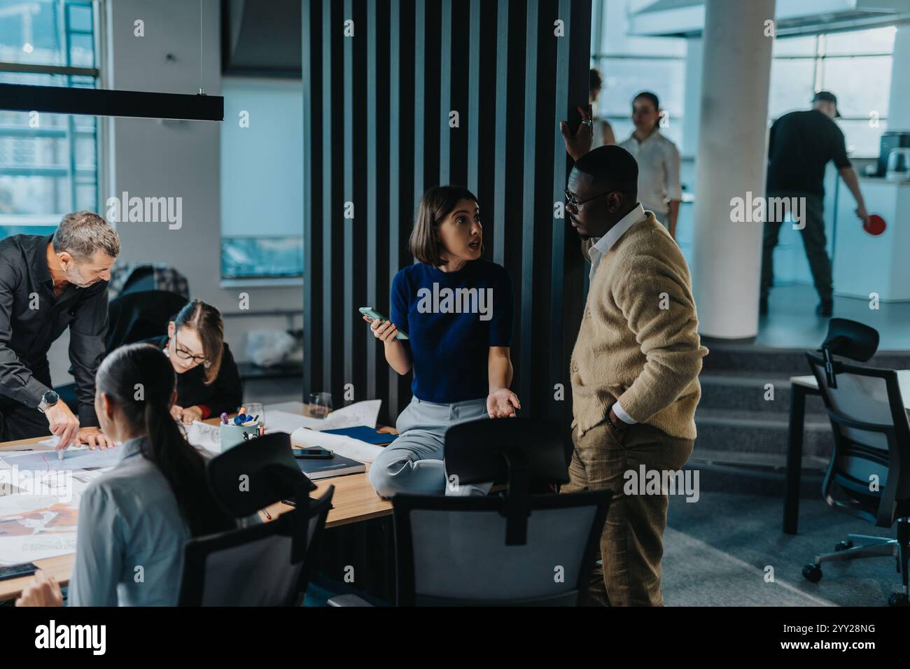 A diverse group of business people collaborate on a project in a modern ...