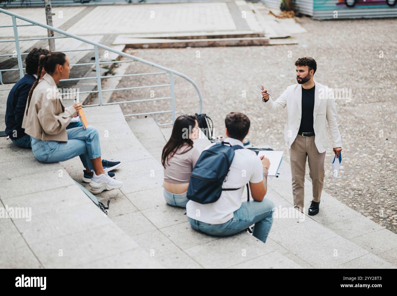 Group of students learning outdoors with attentive professor Stock ...
