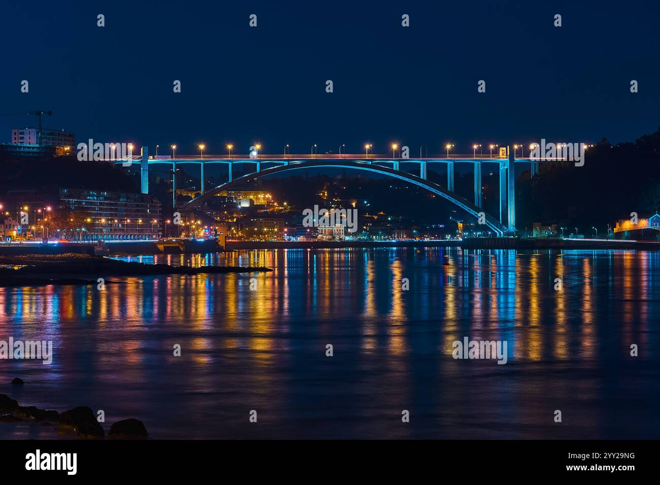 Illuminated Bridge at Night Reflecting Vibrant City Lights on Calm ...