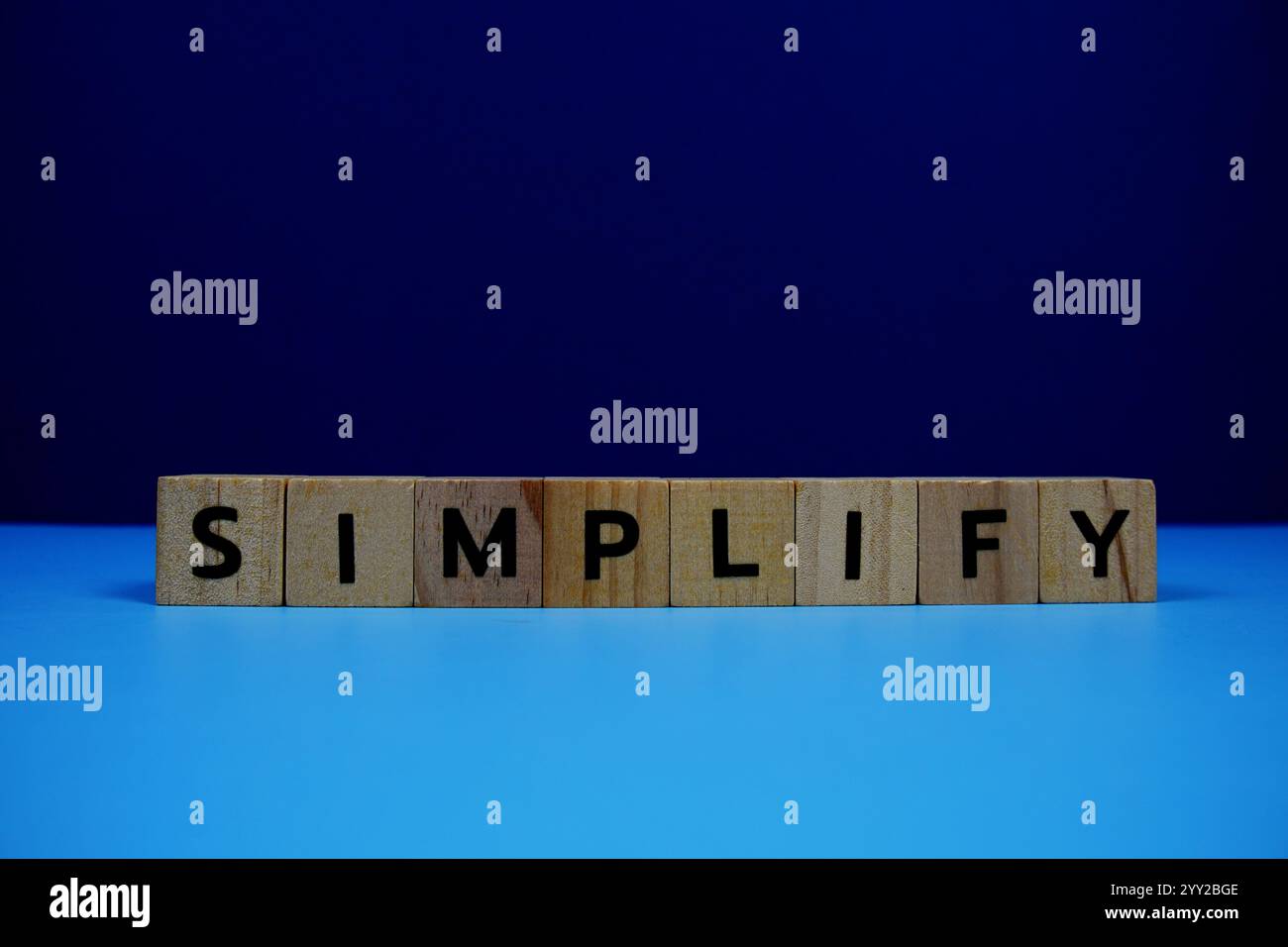 SimplifySimplify with wooden blocks alphabet letters on blue background ...