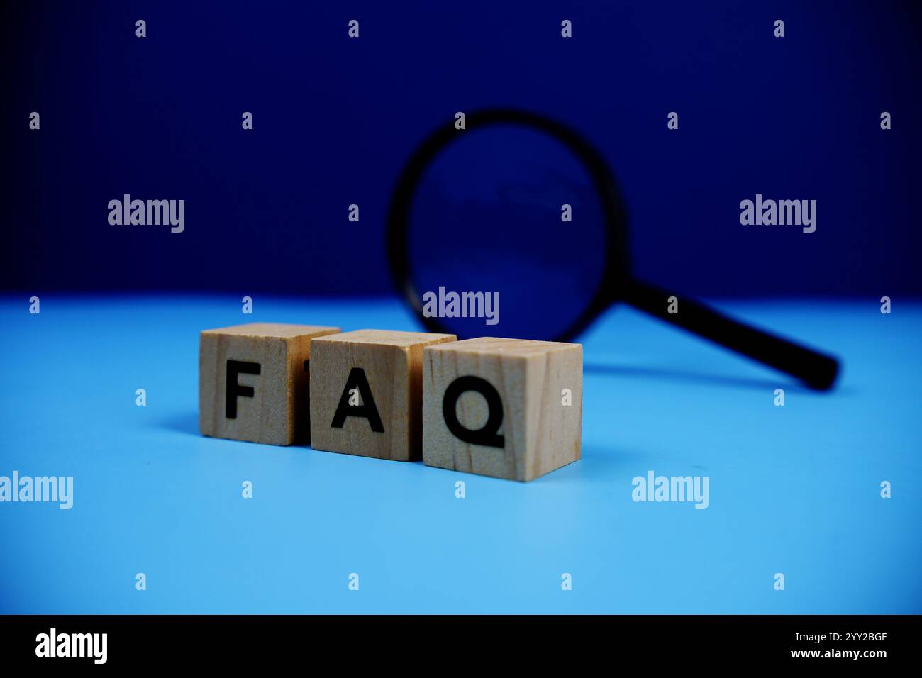 FAQ with wooden blocks alphabet letters and Magnifying glass on blue ...