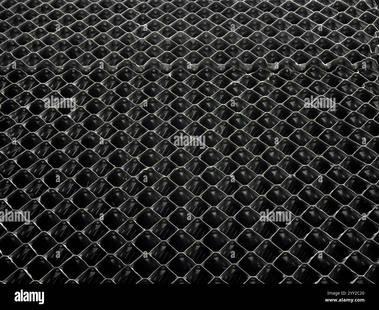 Close up of fabricated black plastic grid, mesh, material in a waste ...