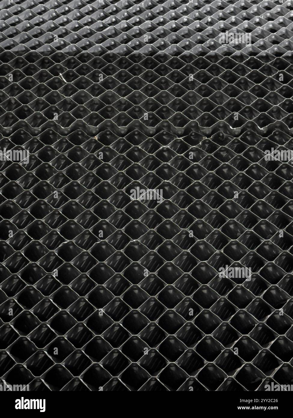 Close up of fabricated black plastic grid, mesh, material in a waste ...