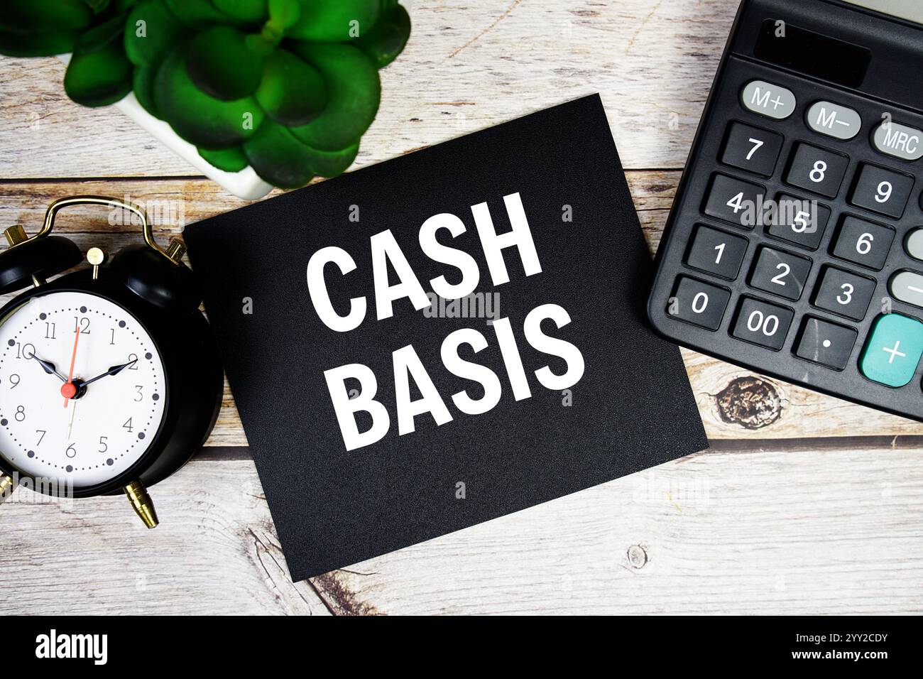 Cash Basis text with alarm clock and calculator on wooden background ...