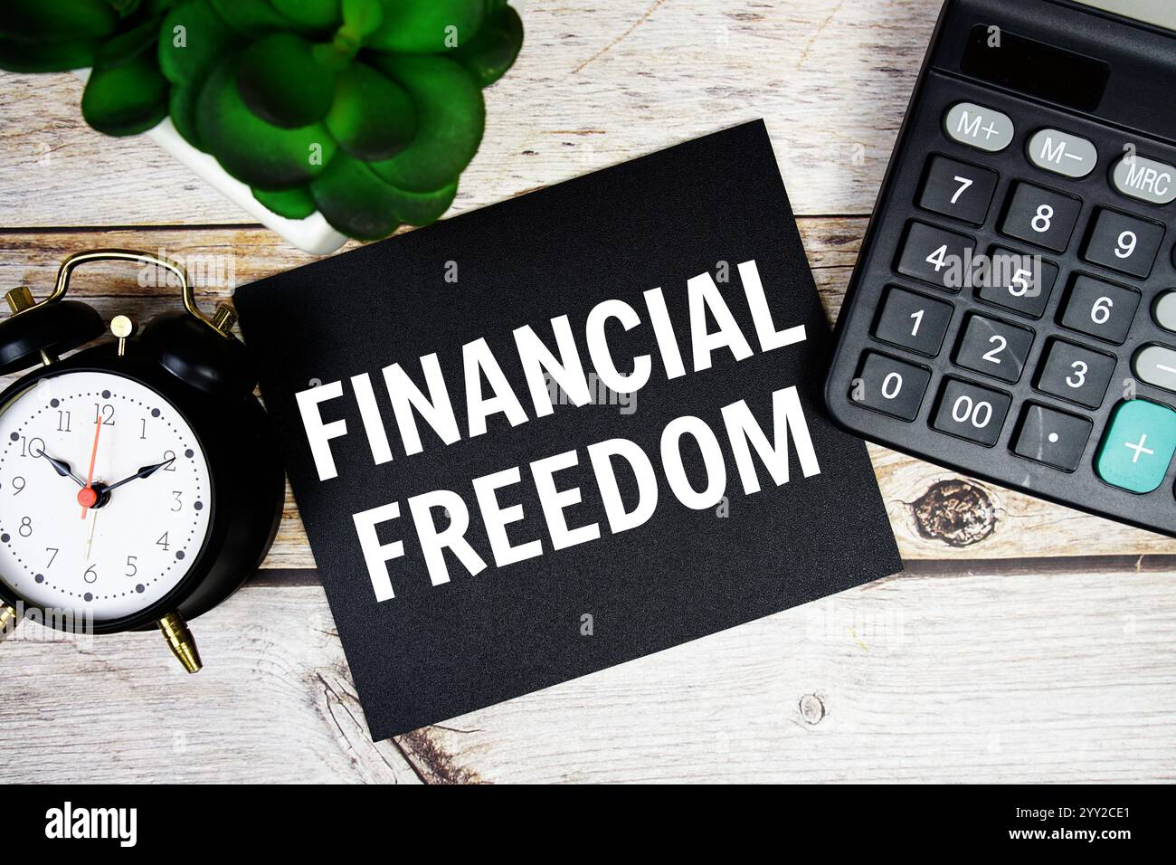 Financial Freedom text with alarm clock and calculator on wooden ...