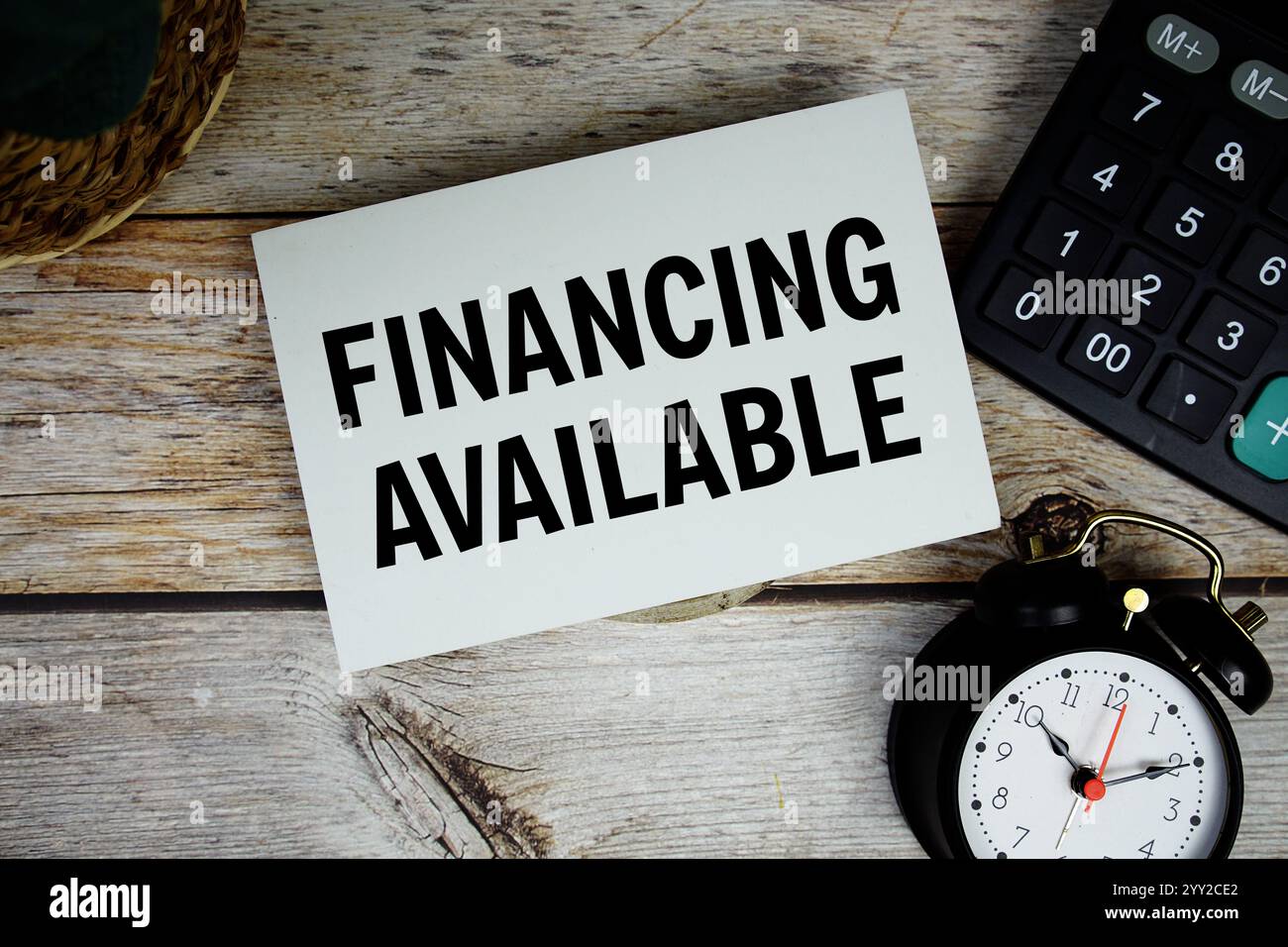 Financing Available text with alarm clock and calculator on wooden ...