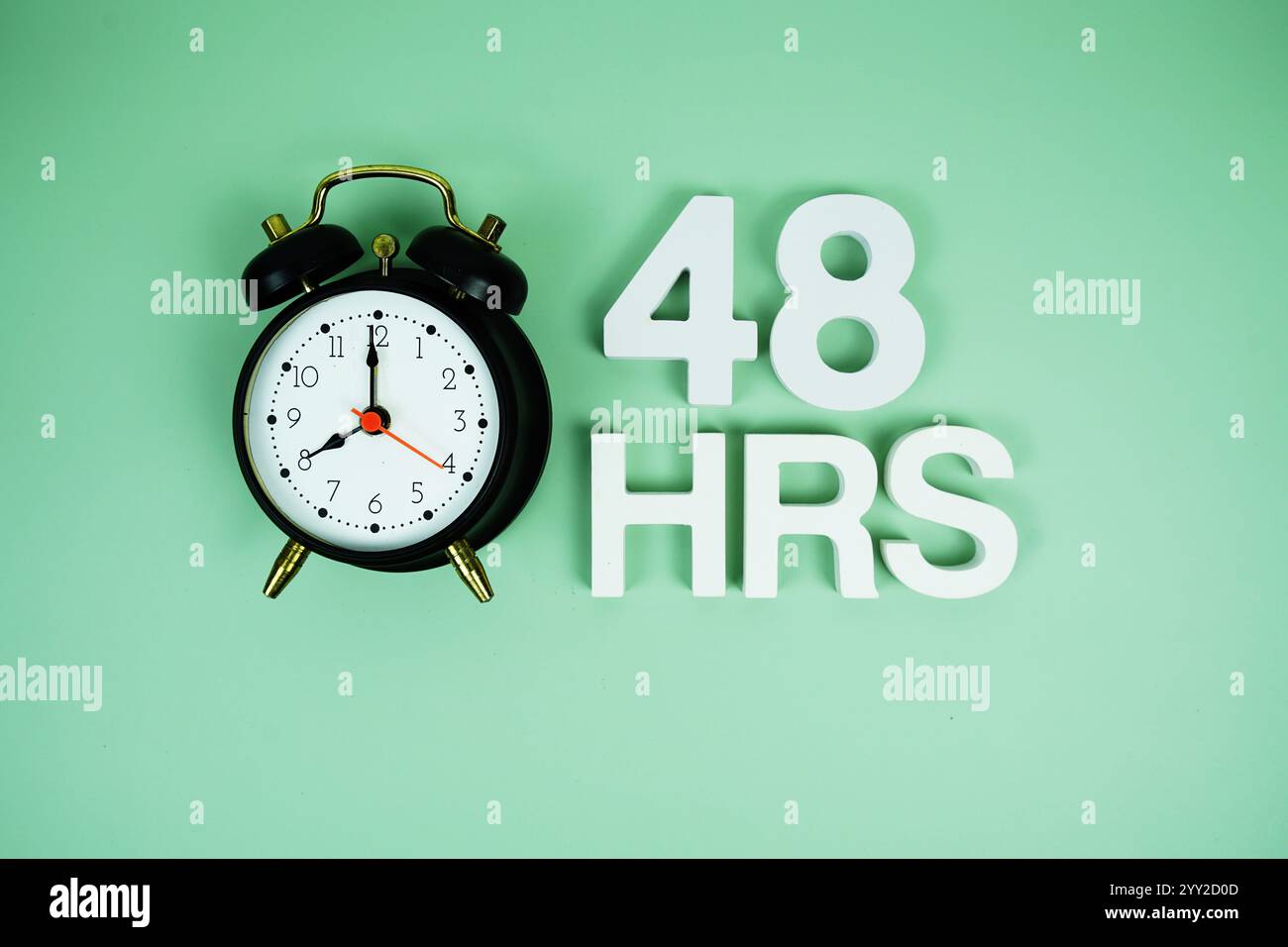 48 Hrs alphabet letters and alarm clock top view on green background ...