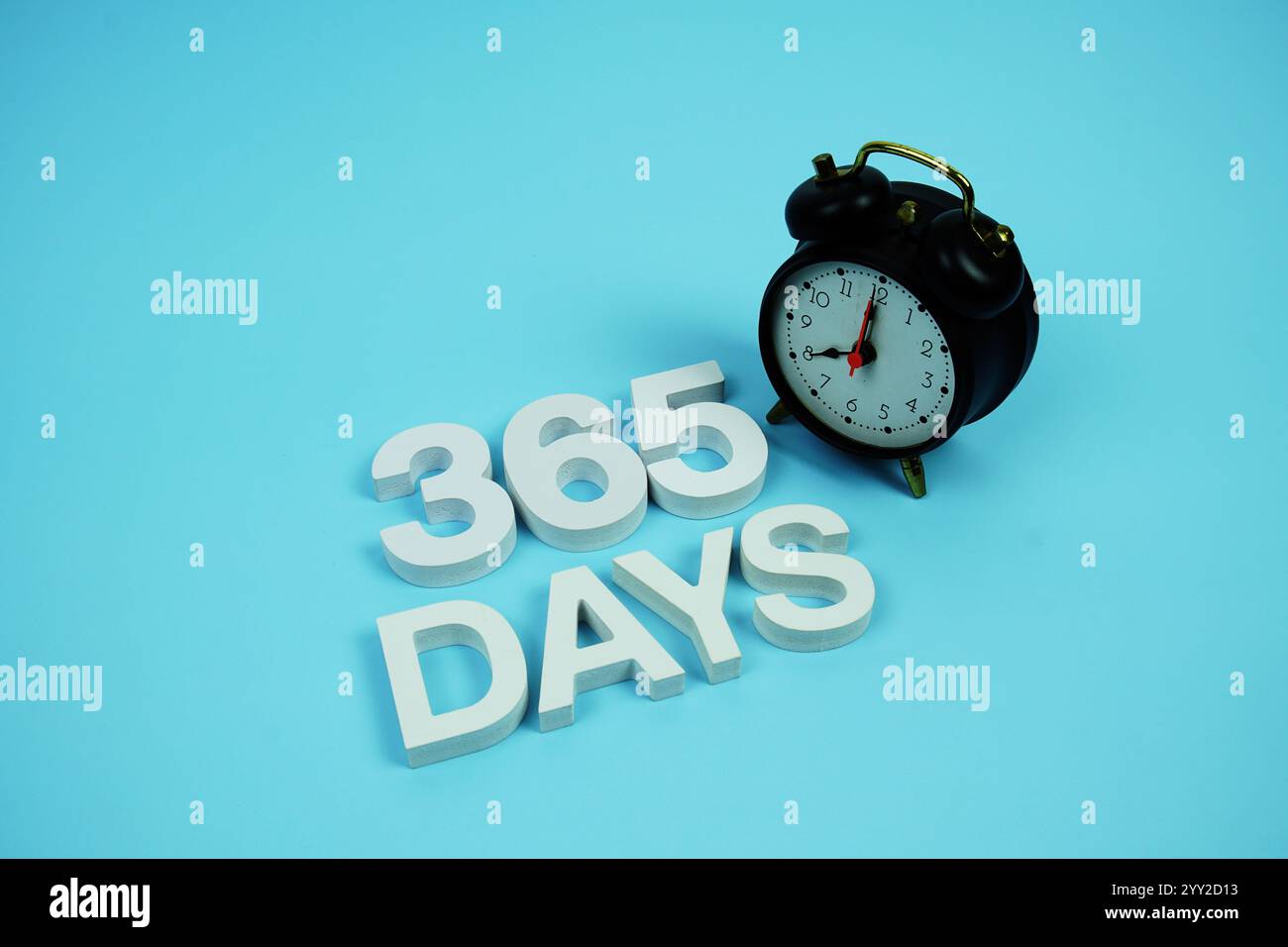 365 Days alphabet letters and alarm clock top view on blue background ...