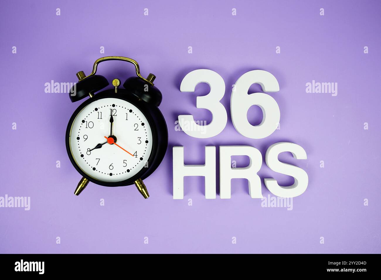 36 Hrs alphabet letters and alarm clock top view on purple background ...