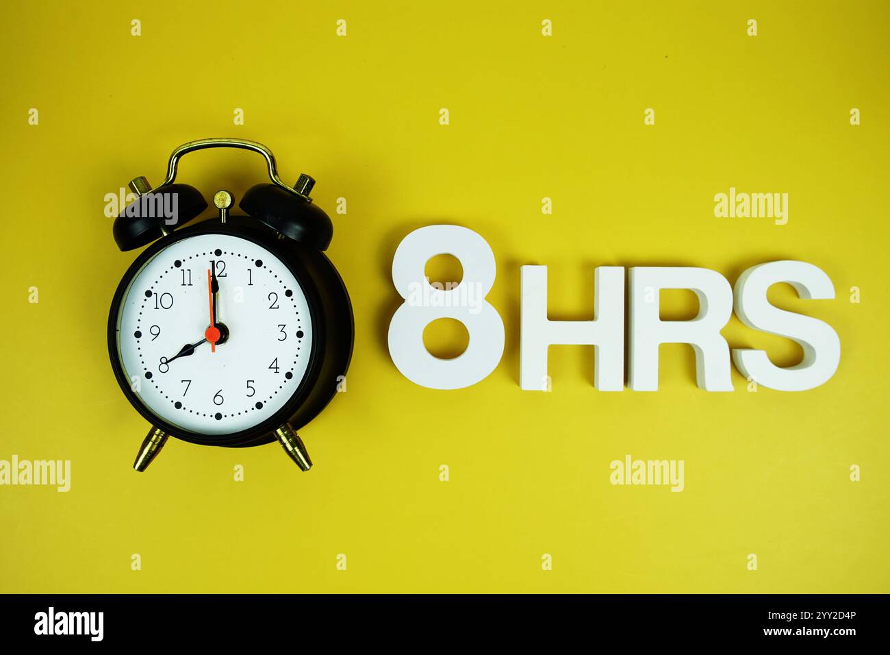 8 Hrs alphabet letters and alarm clock top view on yellow background ...
