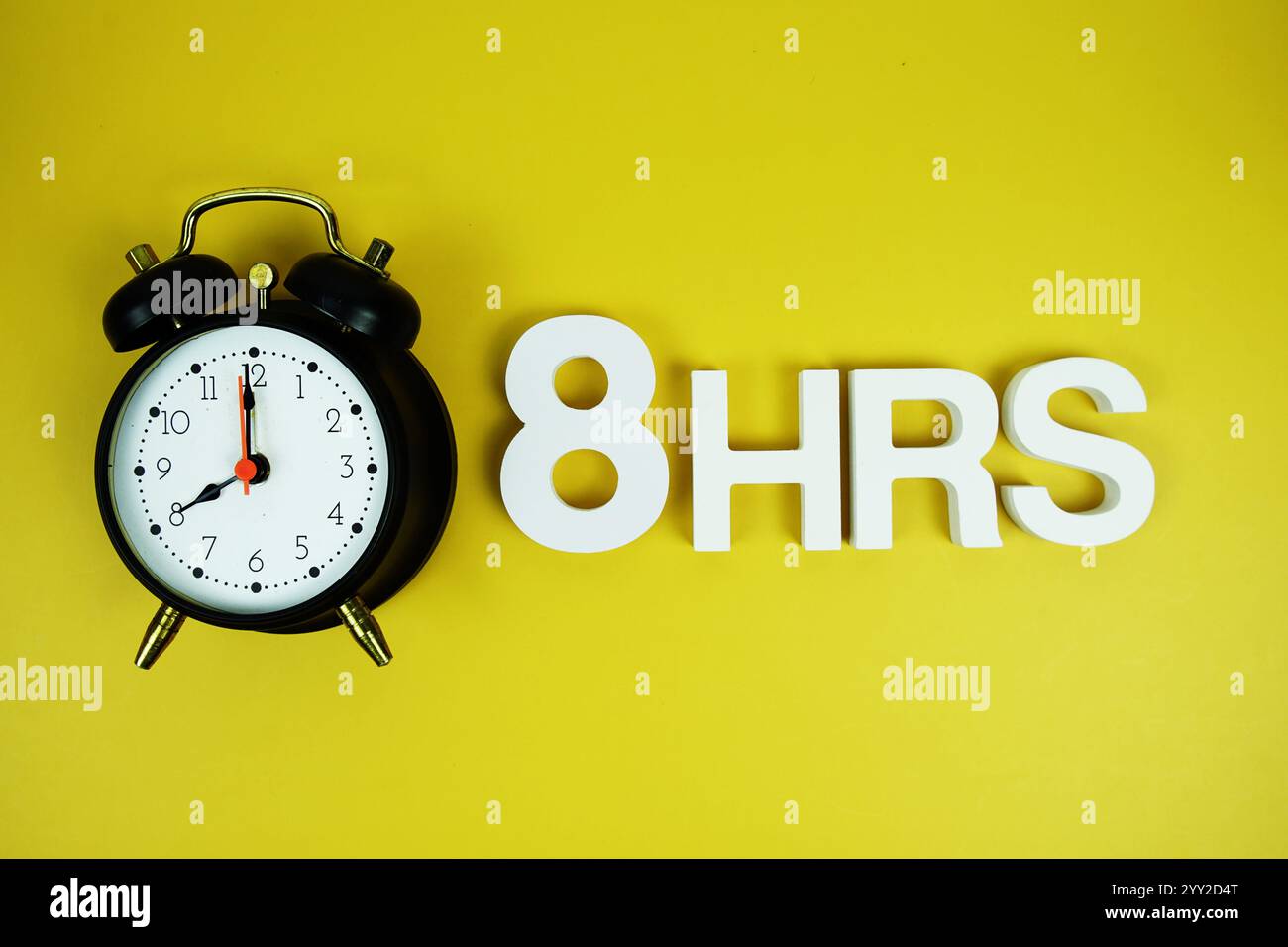 8 Hrs alphabet letters and alarm clock top view on yellow background ...