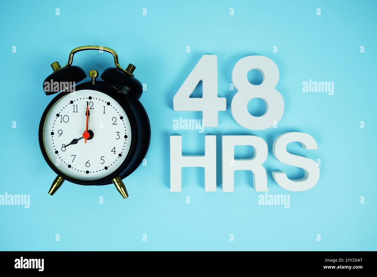 48 Hrs alphabet letters and alarm clock top view on blue background ...