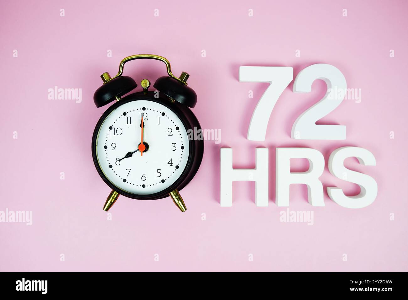 72 Hrs alphabet letters and alarm clock top view on pink background ...