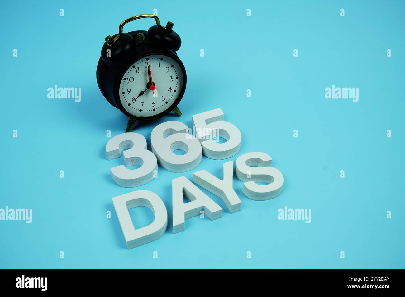 365 Days alphabet letters and alarm clock top view on blue background ...