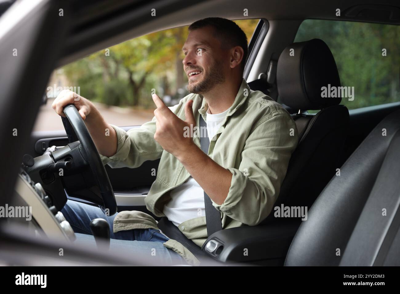 Man driving modern car, view through window Stock Photo - Alamy