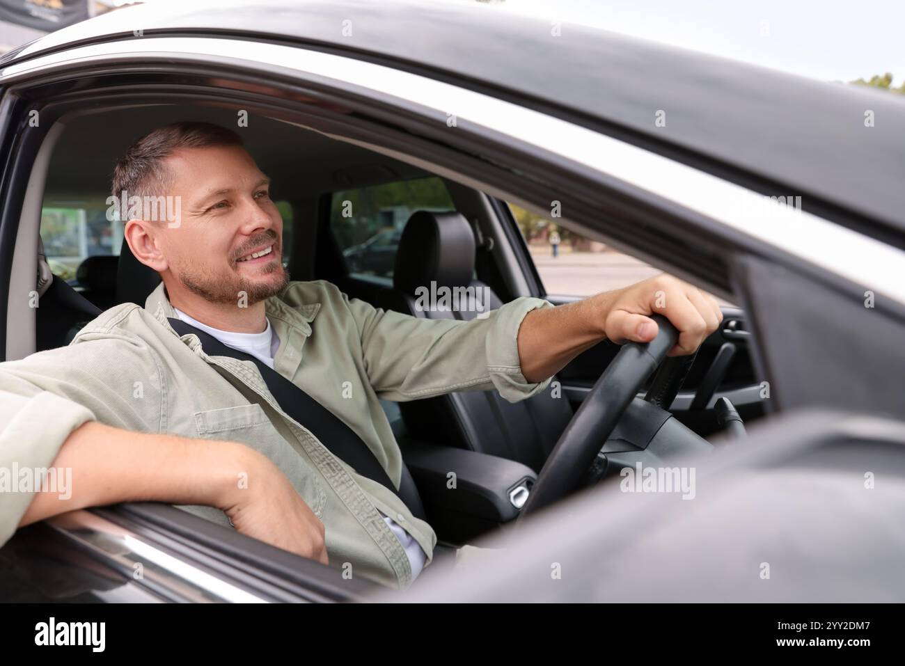 Man driving modern car, view through window Stock Photo - Alamy