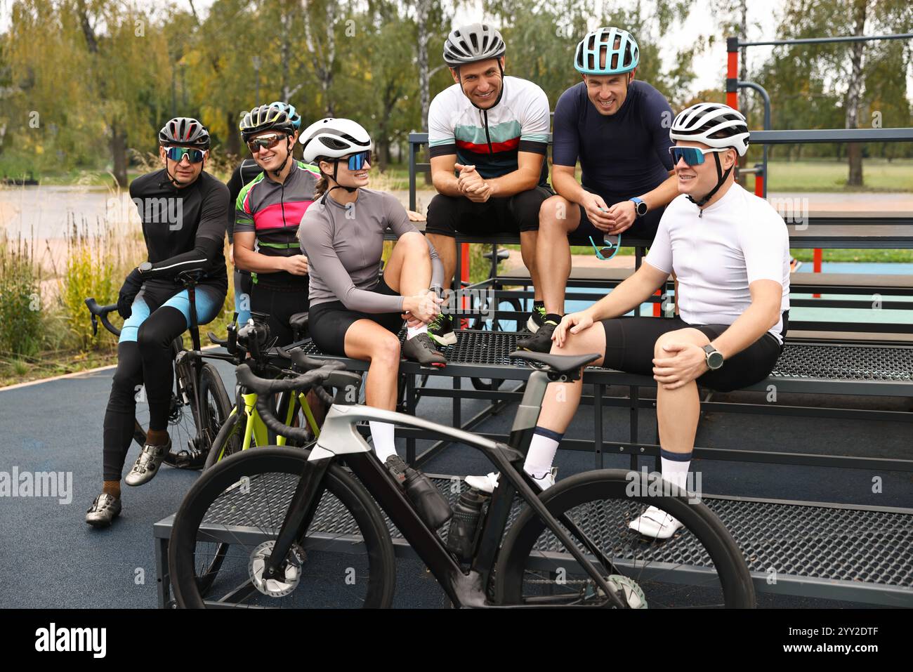 Group of athletic people with helmets and bicycles spending time ...