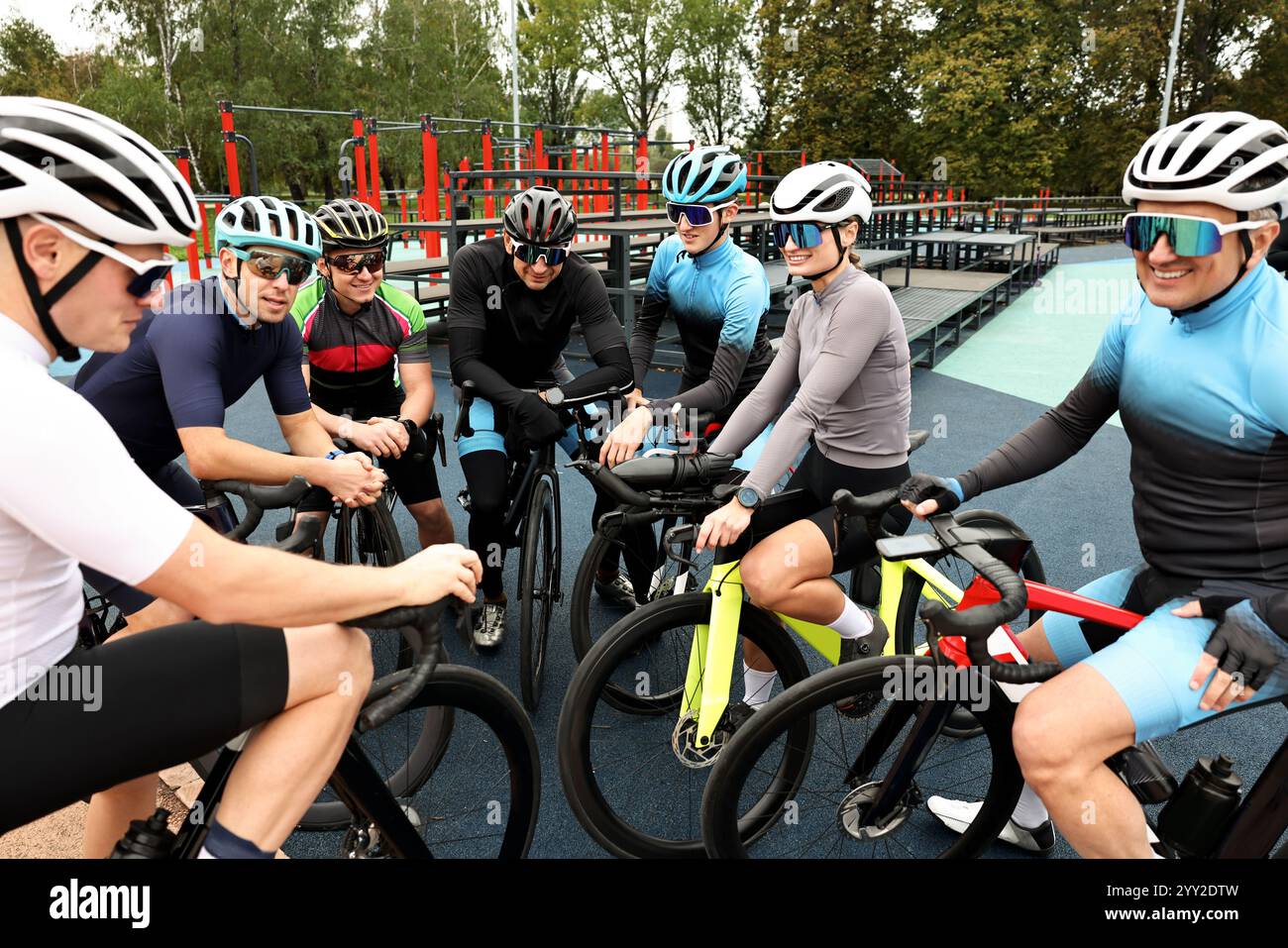 Group of athletic people with helmets and bicycles spending time ...