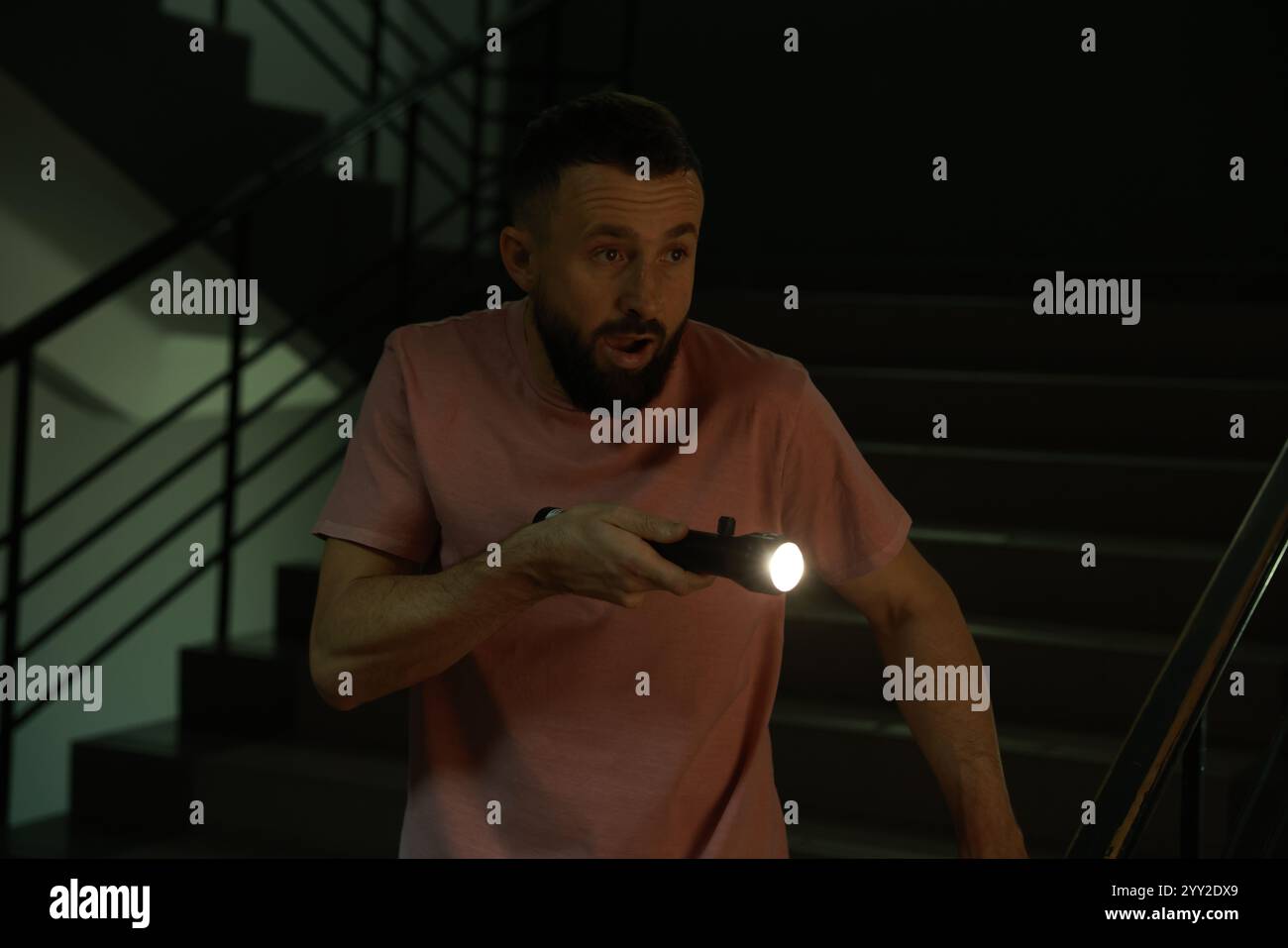 Fear of darkness. Scared man with flashlight indoors at night Stock ...