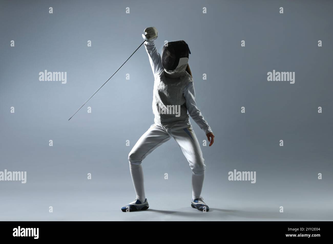 Fencer with epee practicing on gray background Stock Photo - Alamy