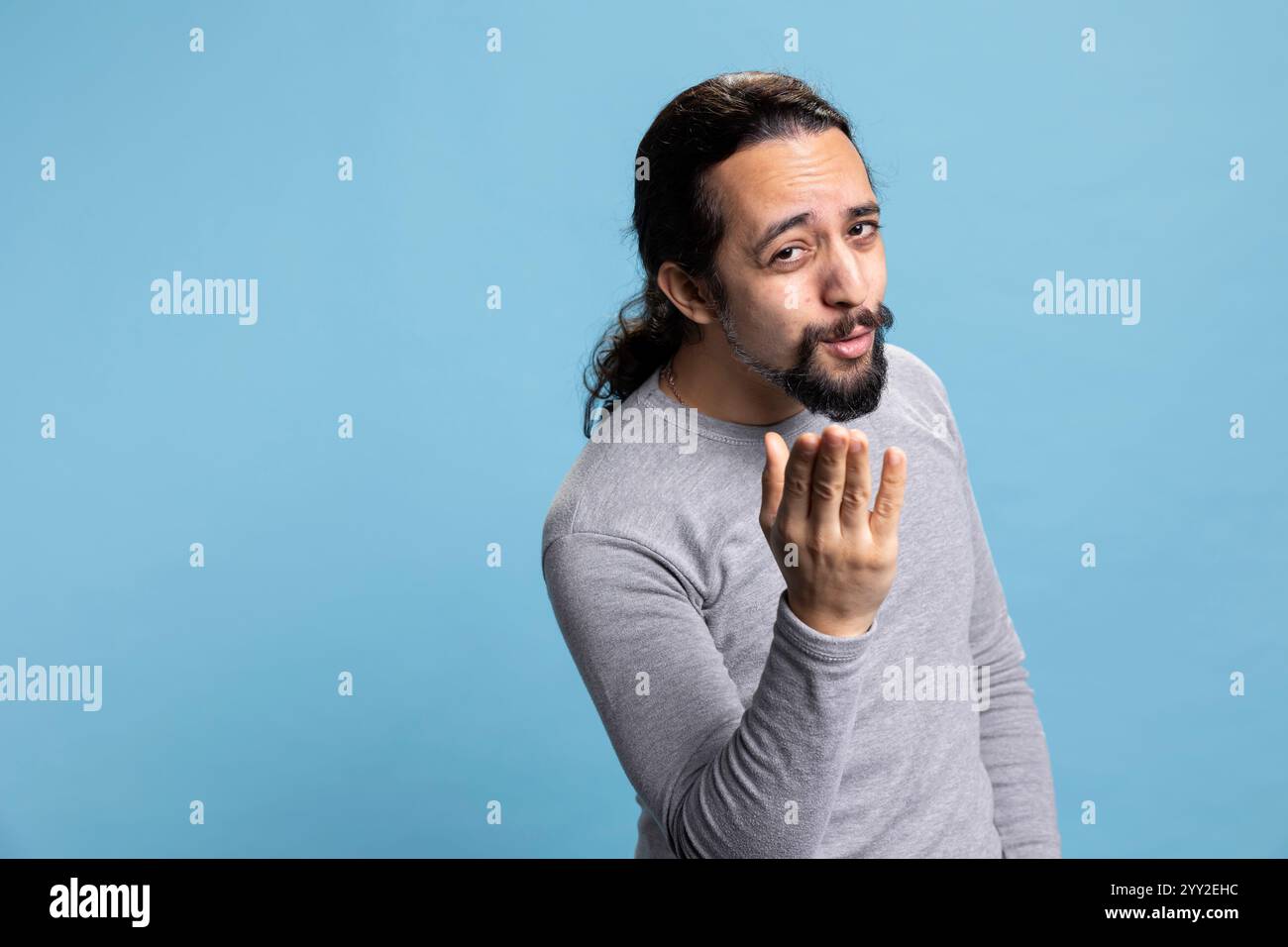 Flirty playful person in casual wear sending air kisses in front of the ...