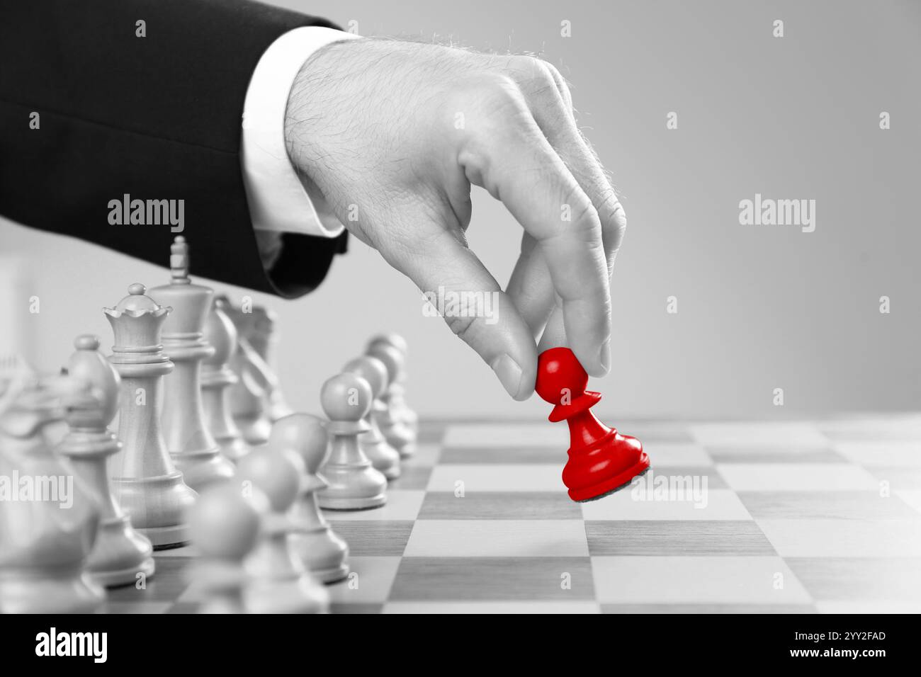 Man making first move by placing red pawn on chessboard, closeup. Black ...