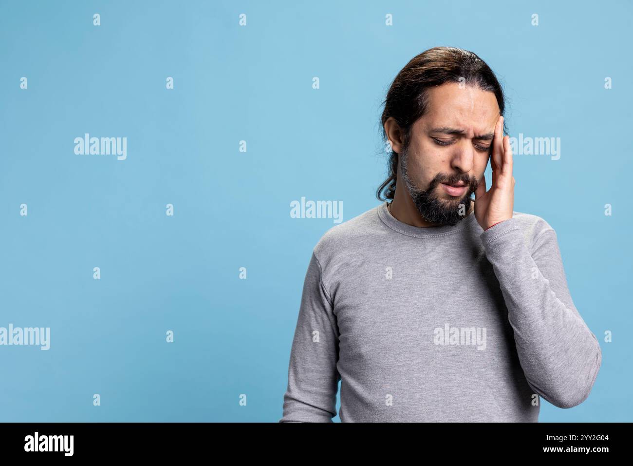 Young adult feeling overwhelmed and worried about his migraine, getting ...