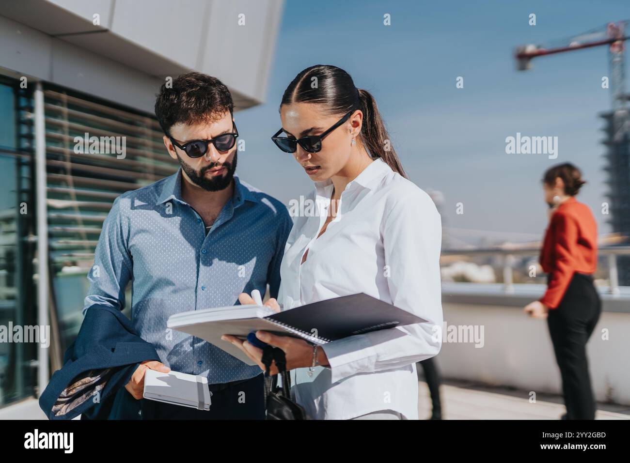 Two business people engage in a serious discussion while reviewing ...