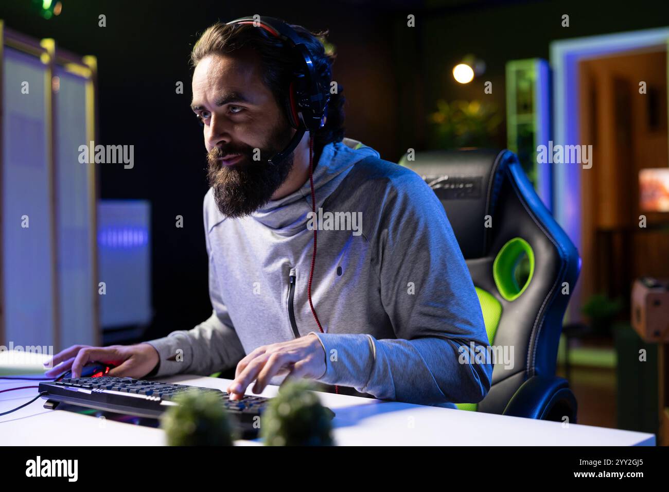 Man powering up computer to play videogames after arriving home in neon ...