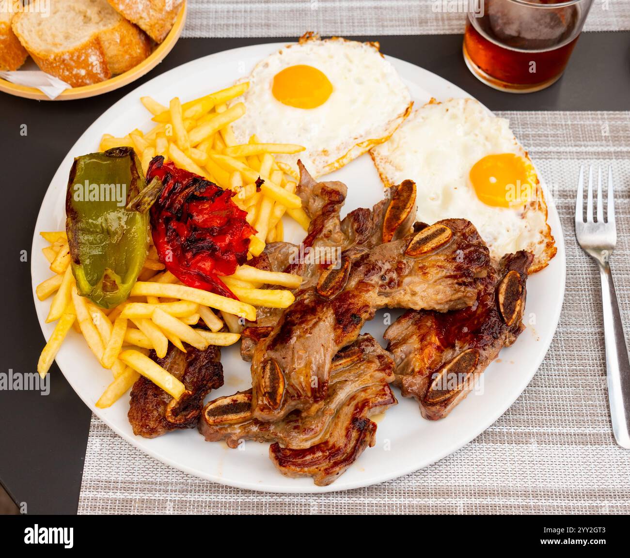 Combination meal of churrasco with french fries, fried eggs and peppers ...
