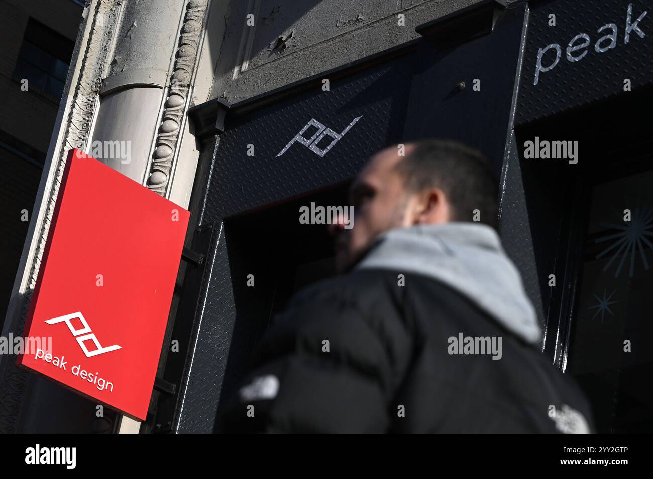 New York, USA. 18th Dec, 2024. A man walks past the Peak Design retail store located in the SoHo ...