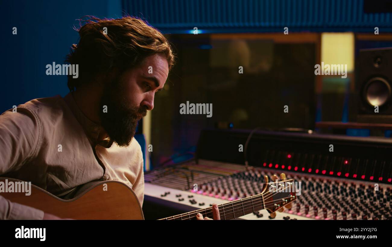 Skilled songwriter guitarist playing musical instrument in professional ...