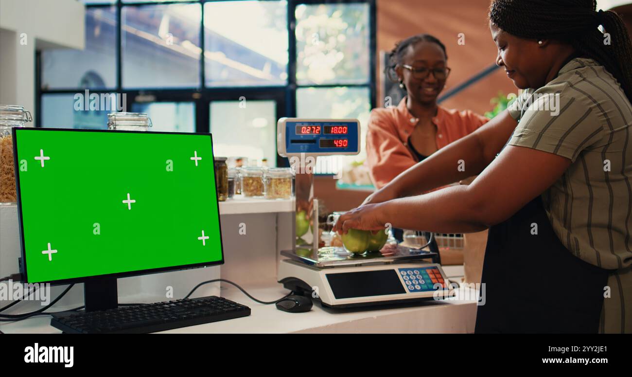 Seller serving customer at counter next to greenscreen layout ...