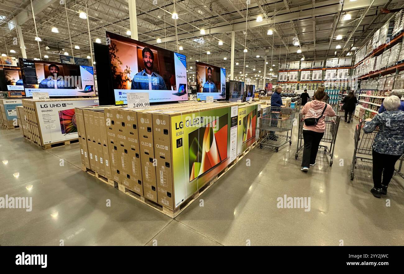 Shoppers pass by displays of large-screen television while entering a ...