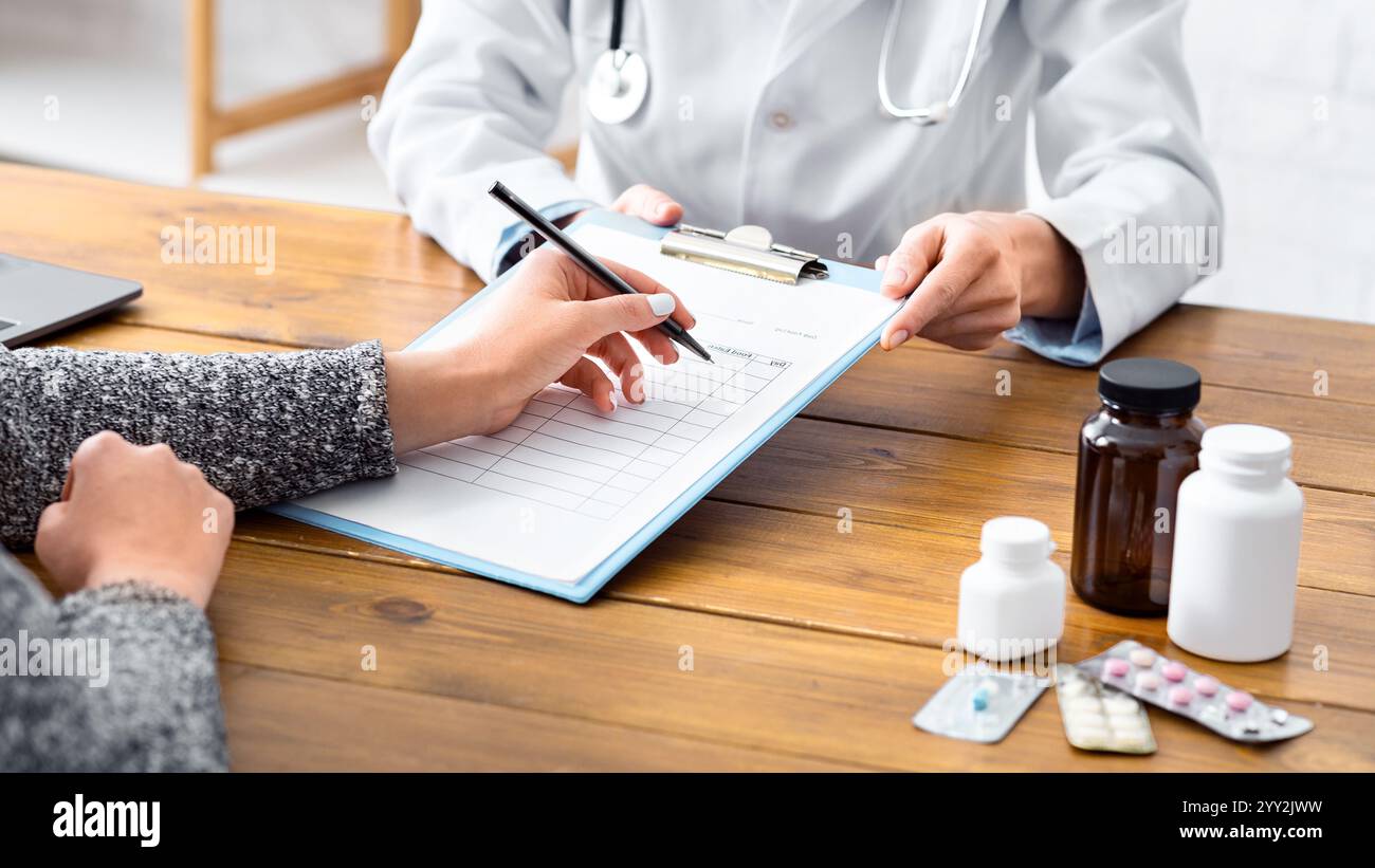 Doctor suggests filling out questionnaire for patients, cropped Stock ...