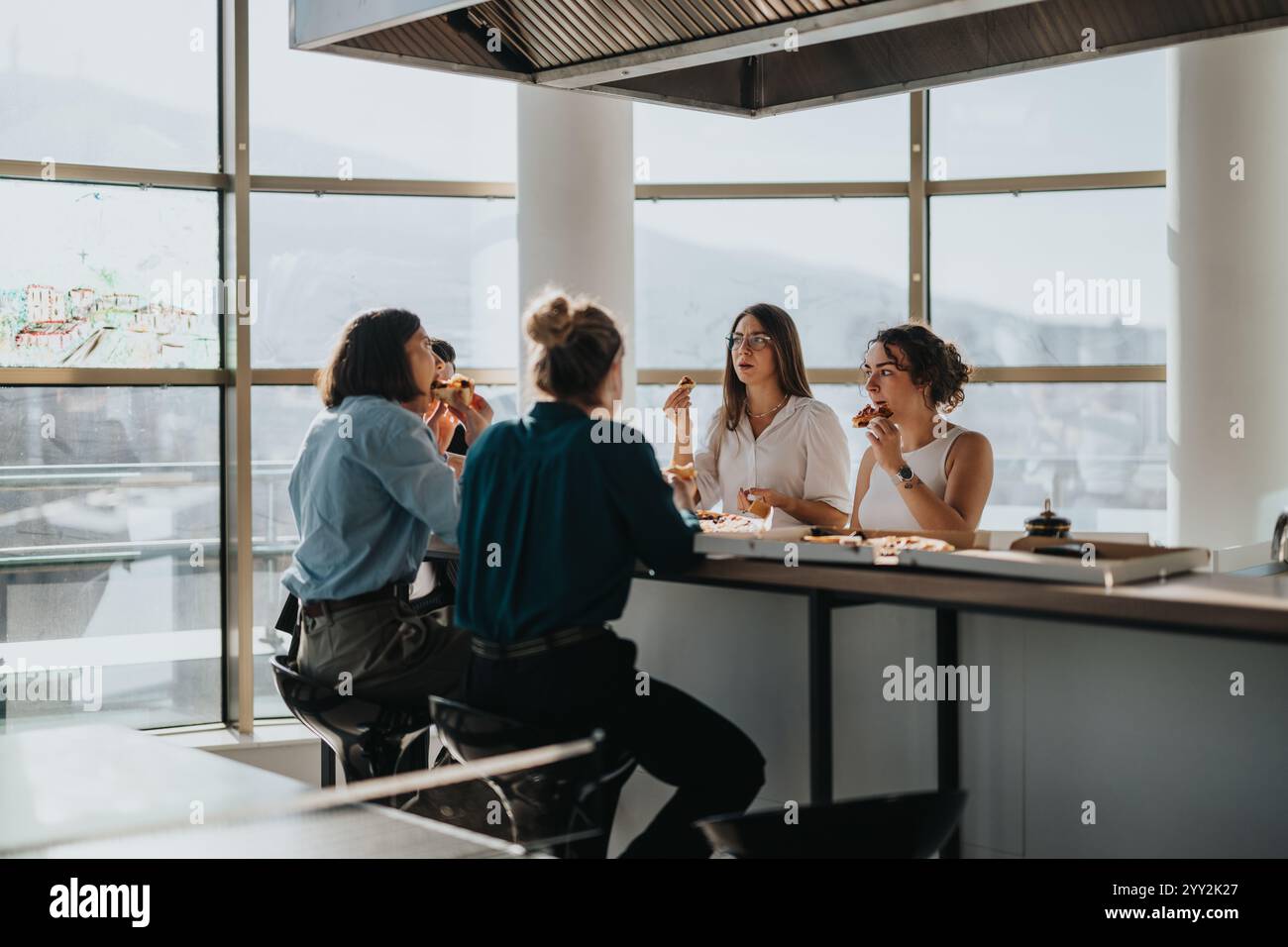 Colleagues enjoy lunch break together at the modern office kitchen ...