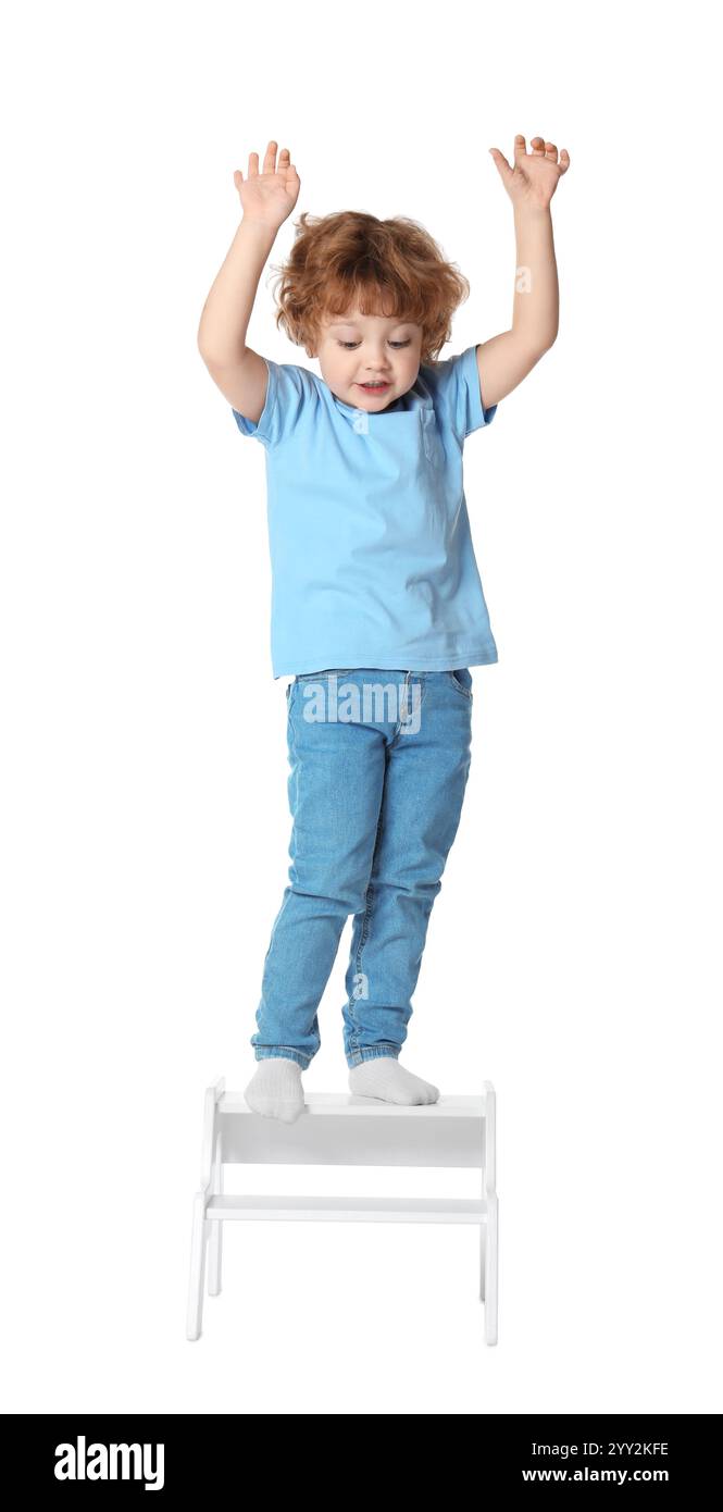 Little boy standing on step stool against white background Stock Photo ...