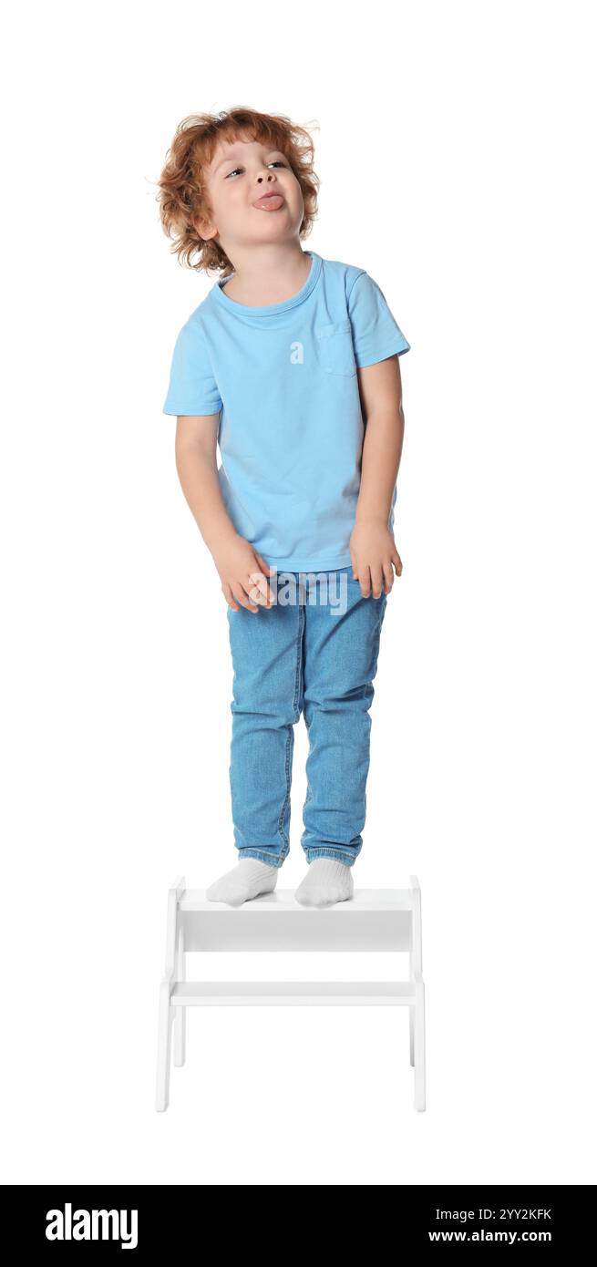 Little boy standing on step stool against white background Stock Photo ...